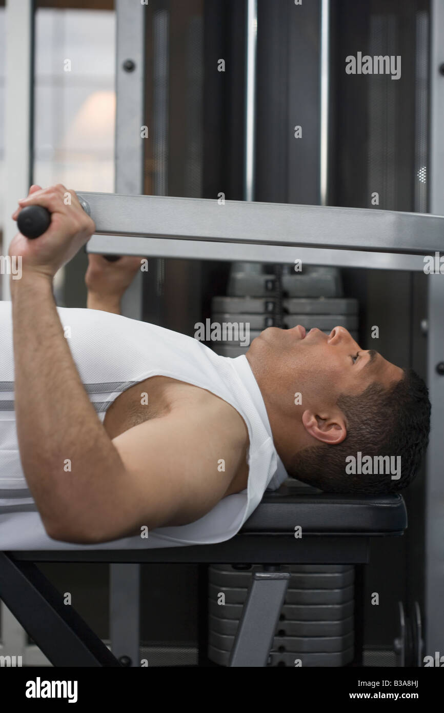 Hispanic man using weight machine Stock Photo - Alamy