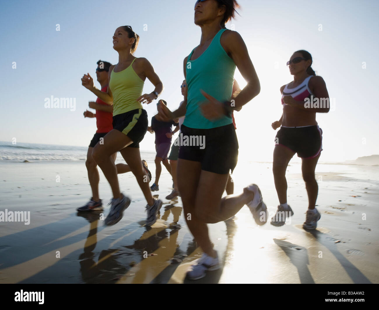 Multi-ethnic runners racing at beach Stock Photo - Alamy