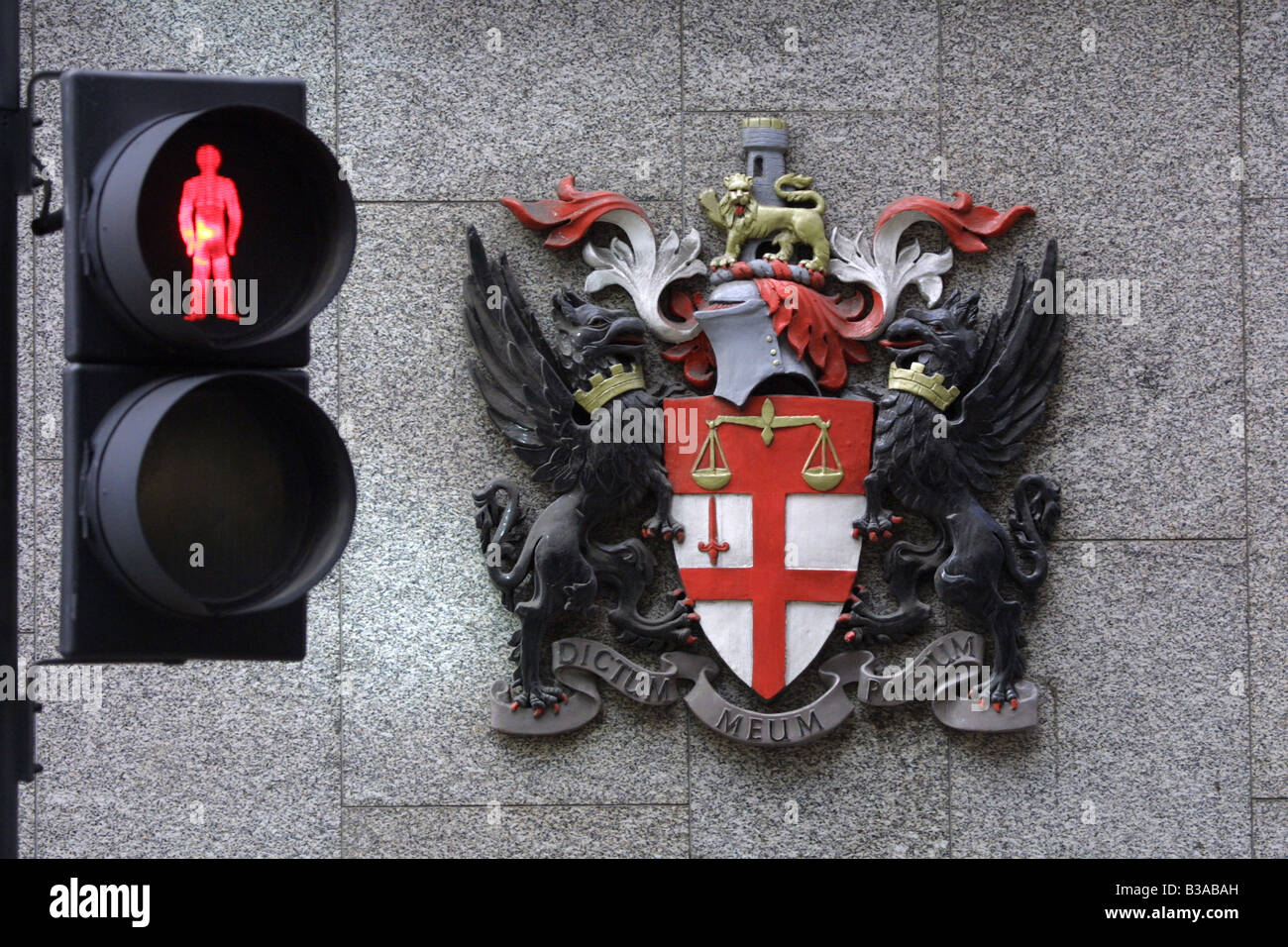 A pedestrian crossing light infront of a City of London emblem London ...