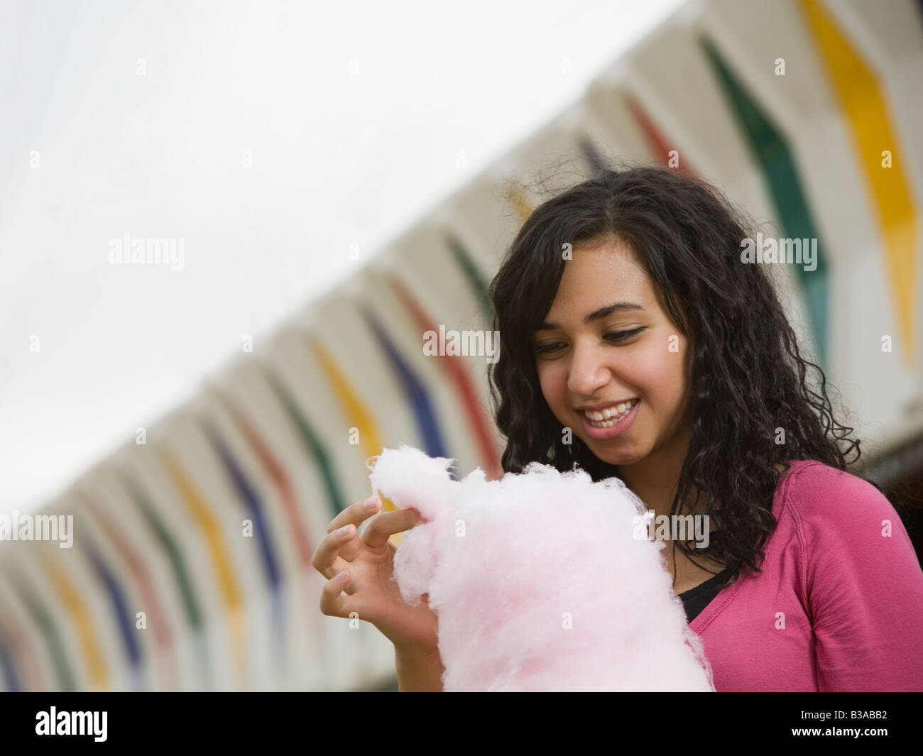 Mixed Race girl eating cotton candy Stock Photo - Alamy
