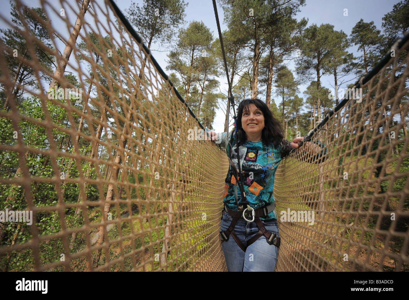 A woman walking over a rope bridge at the Go Ape Forest Park, Exeter ...