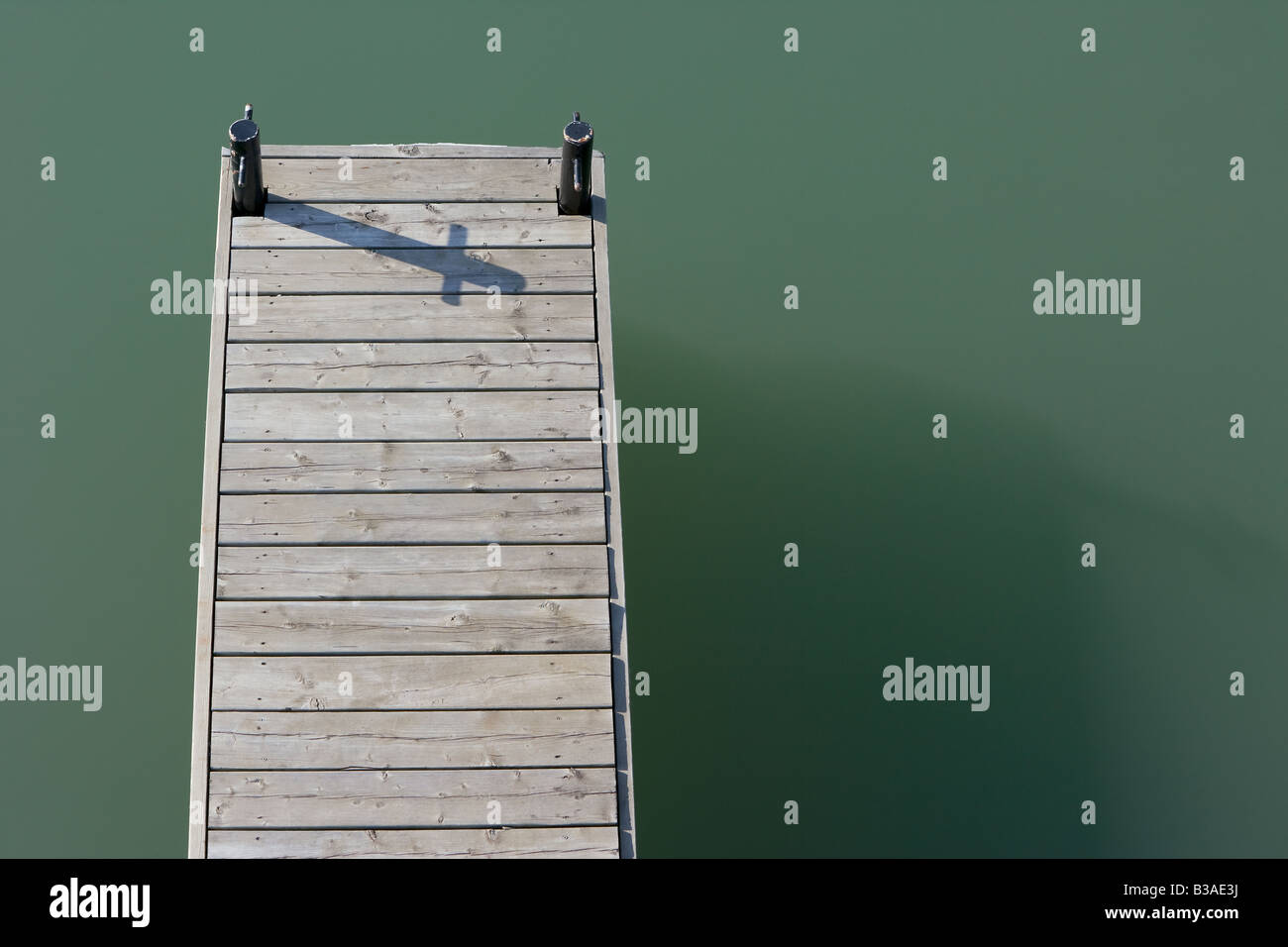 A small wooden dock on a green lake Stock Photo - Alamy