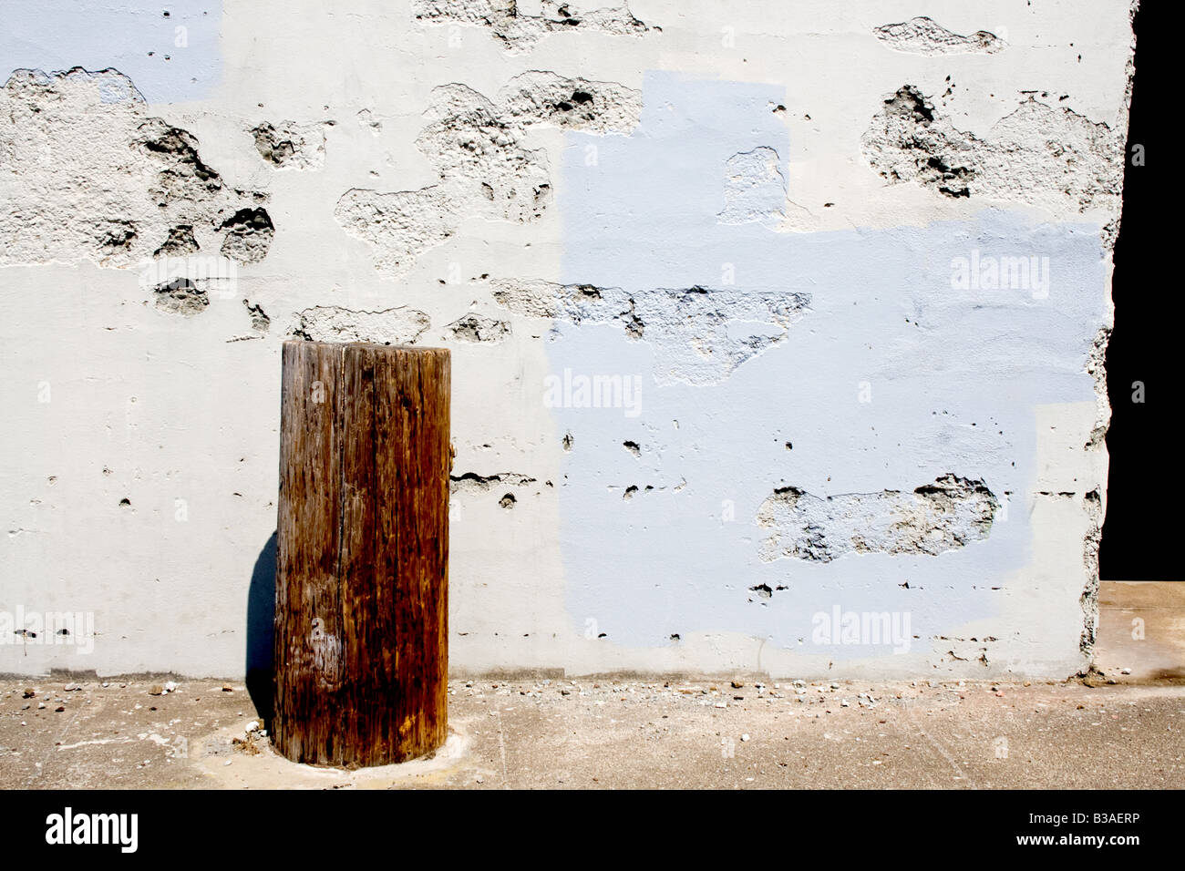 Round wooden post in front a white wall Stock Photo - Alamy