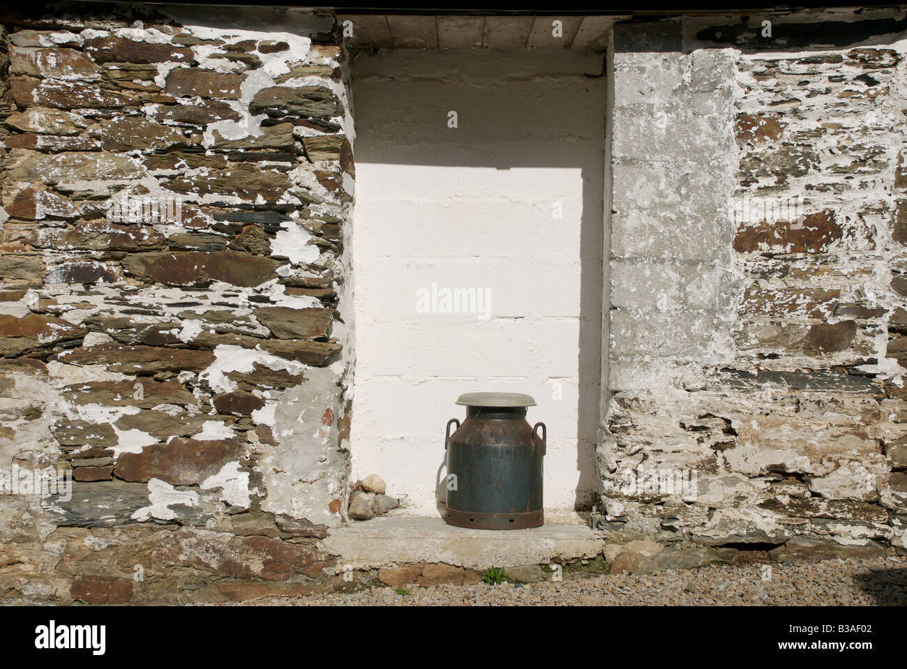 Metal churn outside old doorway of rural barn Stock Photo - Alamy