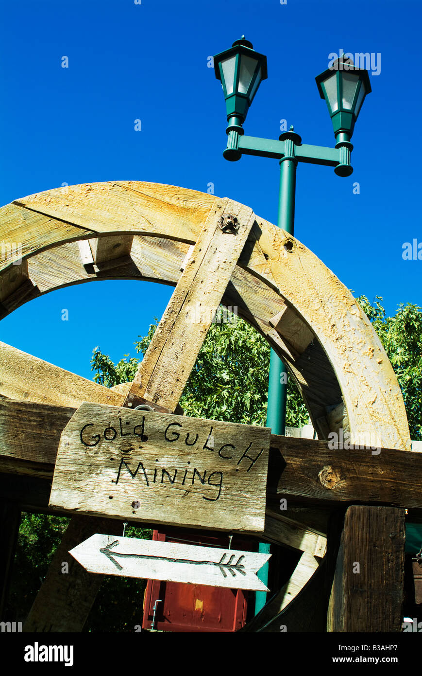 rural gold gulch mining sign with a old water wheel and lanterns in ...