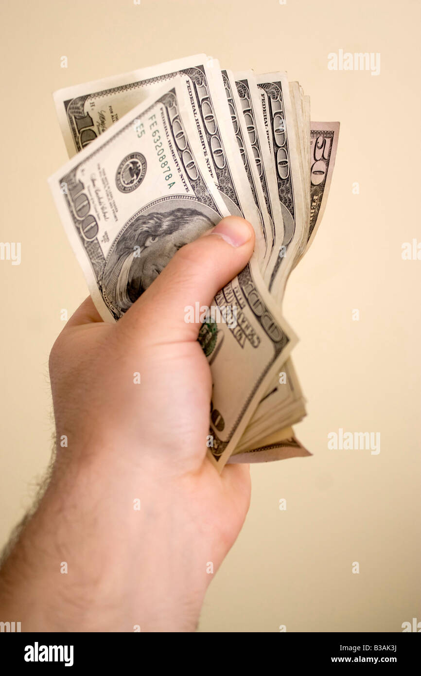 A handful of cash isolated over a solid background Stock Photo - Alamy