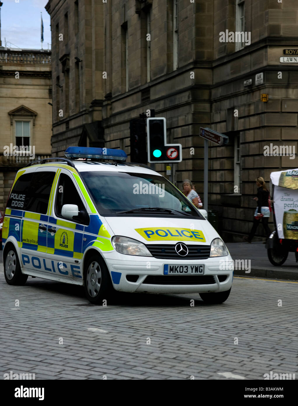 Police vehicle being driven through a junction with traffic lights ...