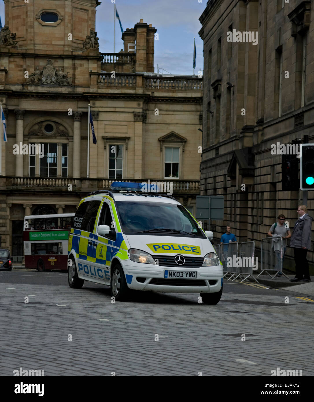 Police vehicle being driven through a junction with traffic lights ...