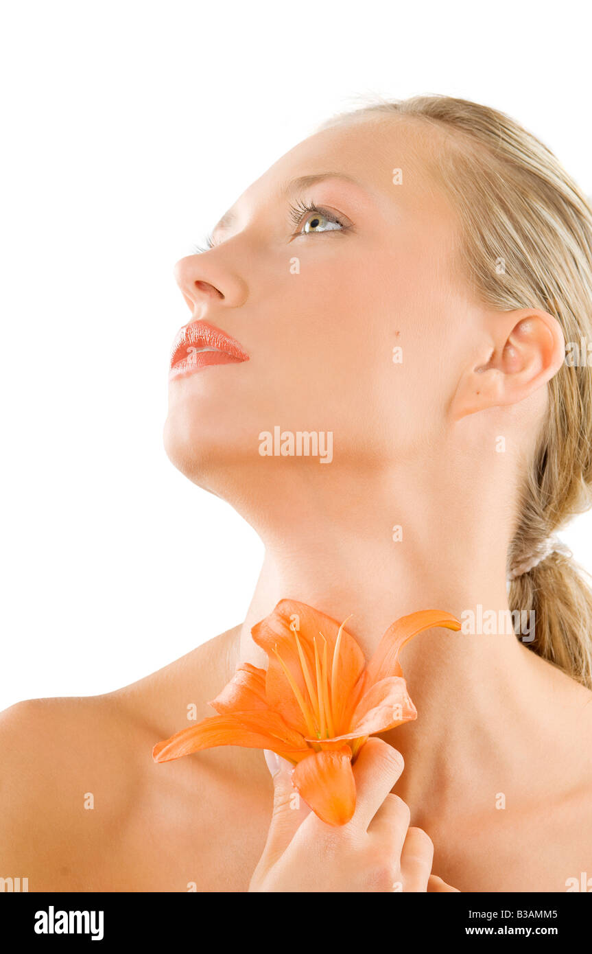 pretty blond girl with fair eyes looking up with a flower in hand Stock ...