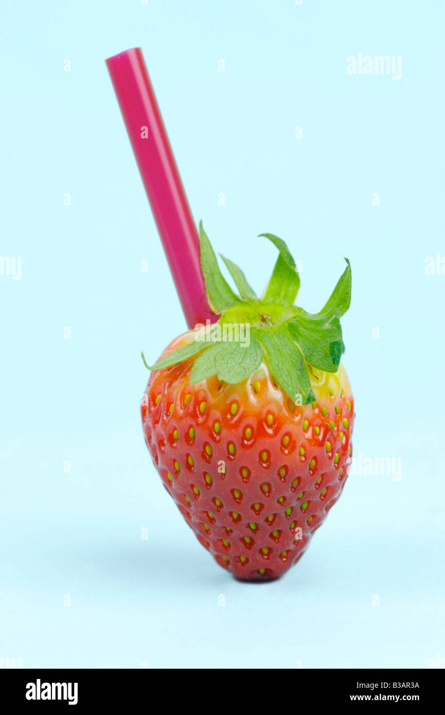 A strawberry with a straw isolated against a blue background Stock ...