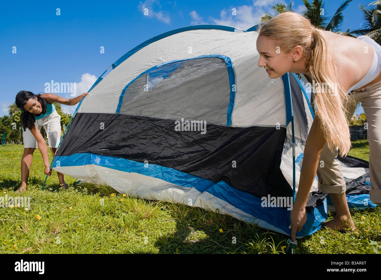 Hispanic women setting up tent Stock Photo - Alamy