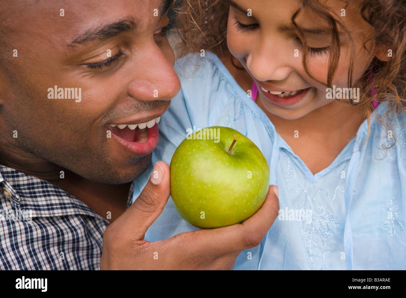 African father and daughter eating apple Stock Photo - Alamy