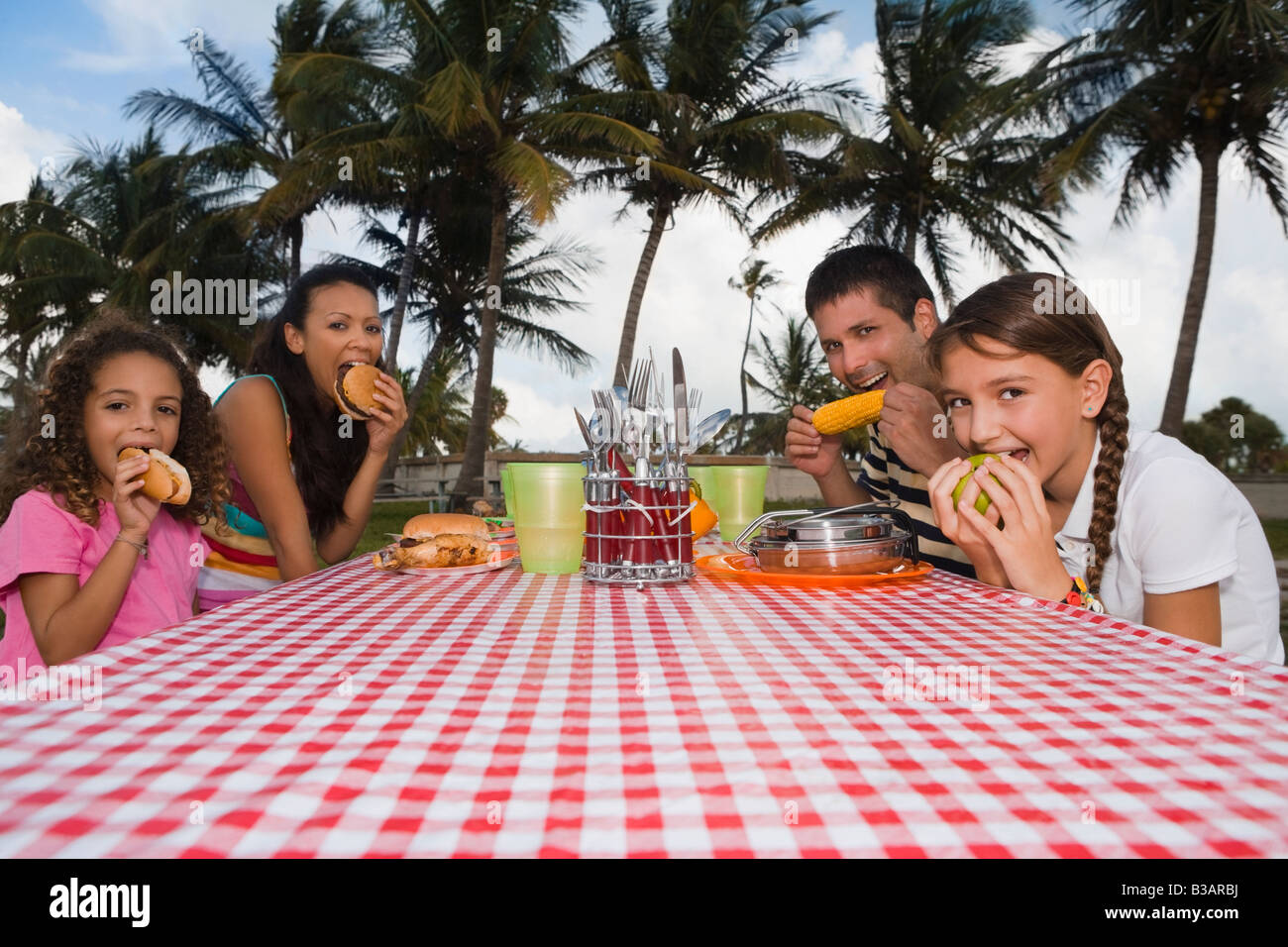 Hispanic family eating at picnic table Stock Photo - Alamy