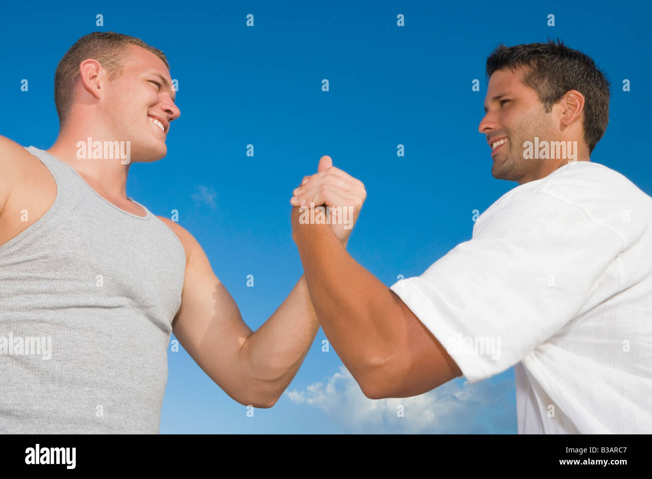Multi-ethnic men clasping hands Stock Photo - Alamy