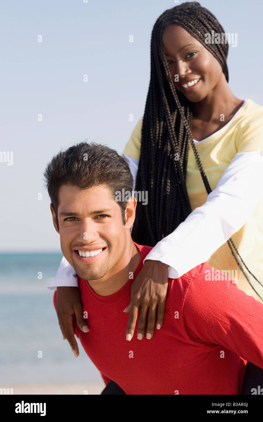 Hispanic man giving girlfriend piggy back ride Stock Photo - Alamy