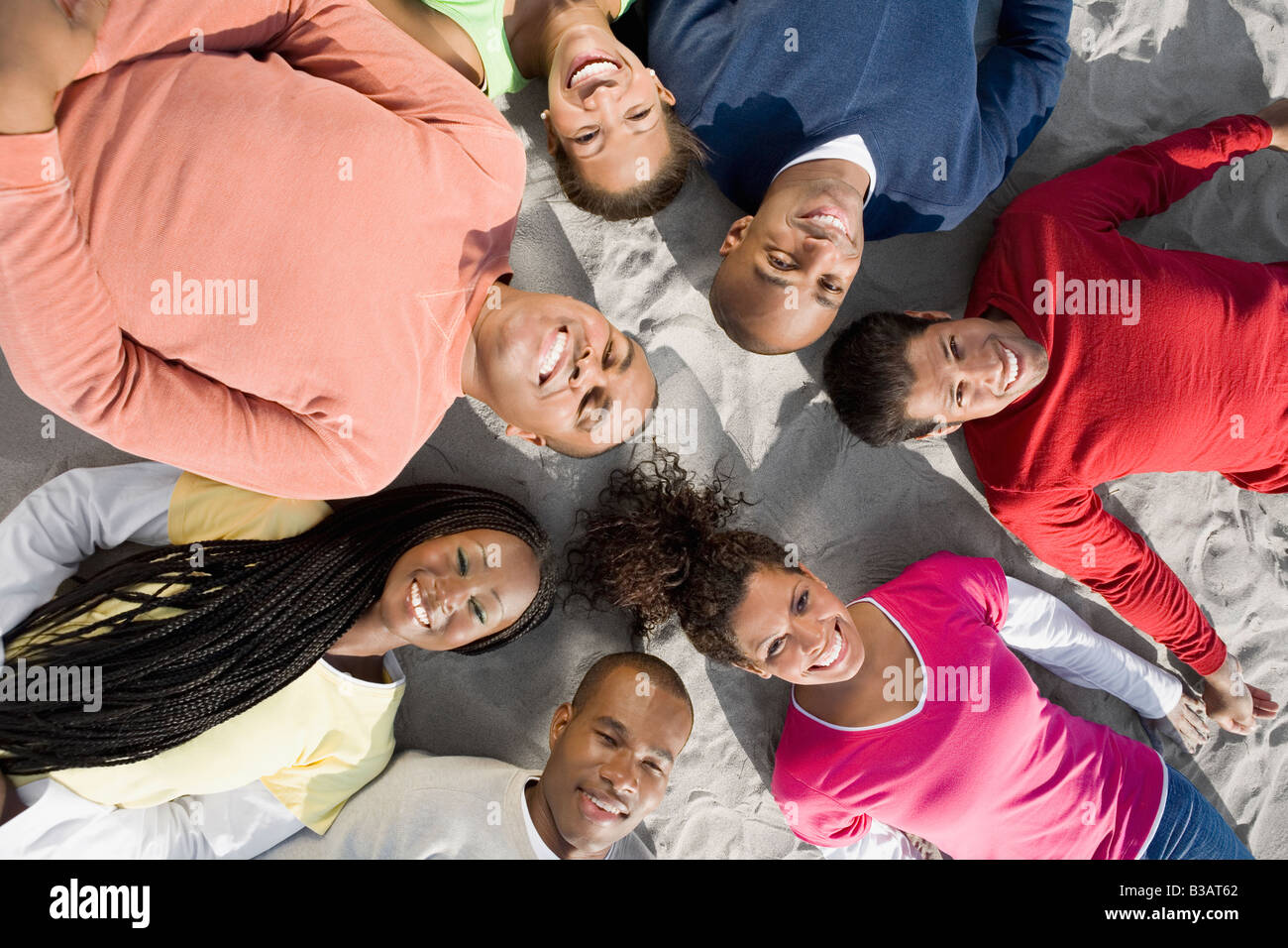 Multi-ethnic friends laying in circle Stock Photo - Alamy