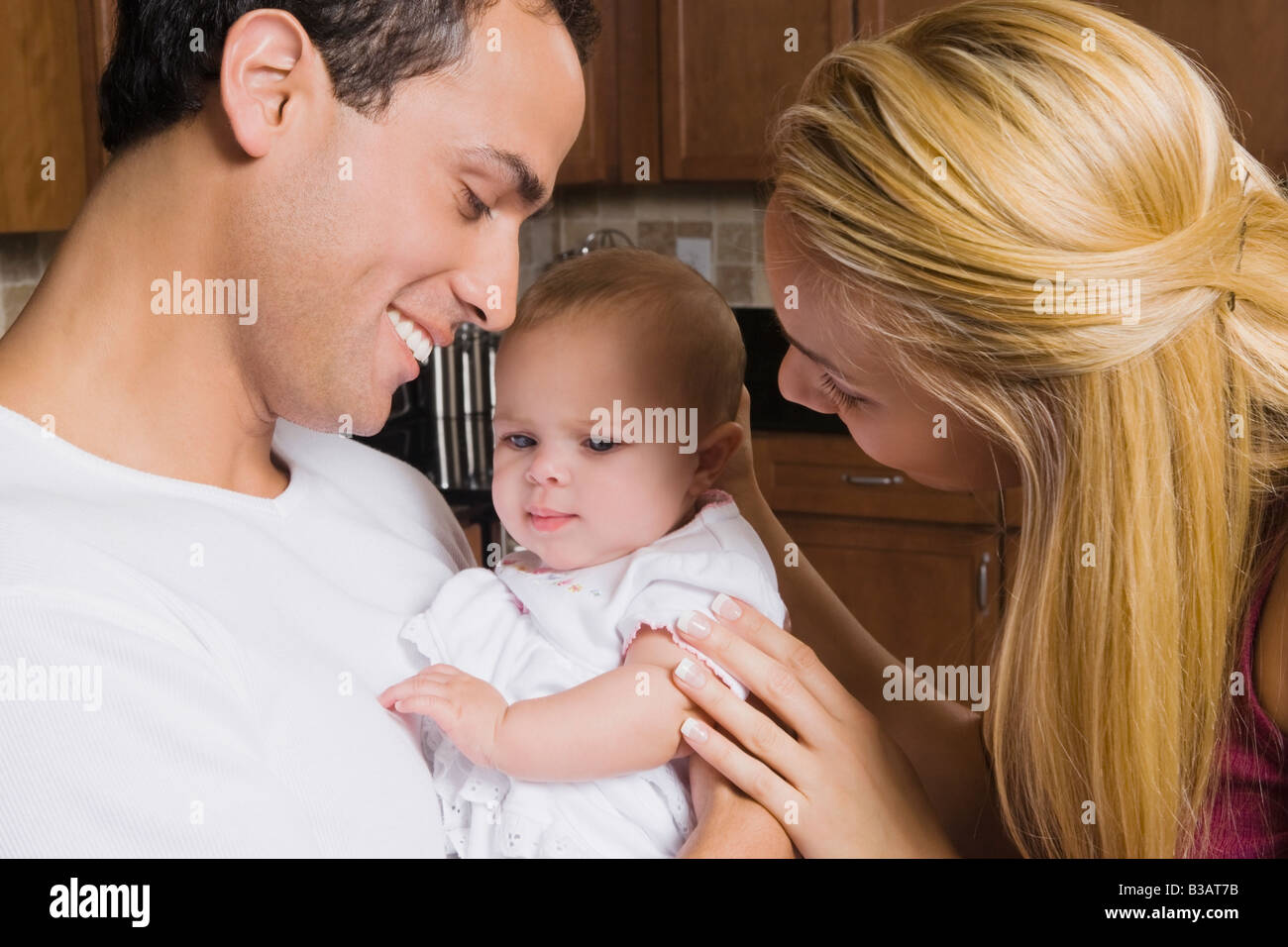 Hispanic parents smiling at baby Stock Photo - Alamy