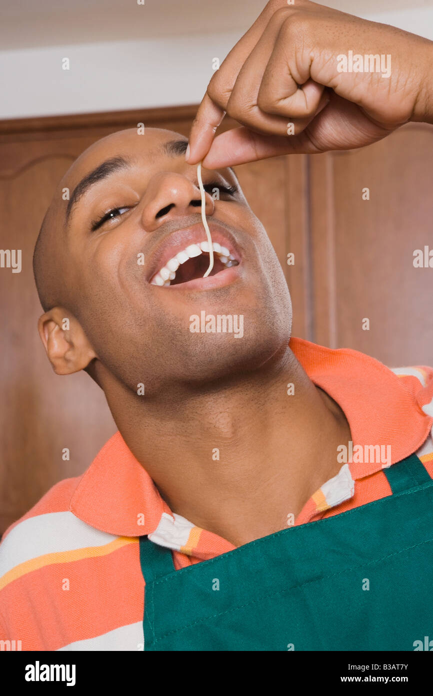 African man eating piece of spaghetti Stock Photo - Alamy