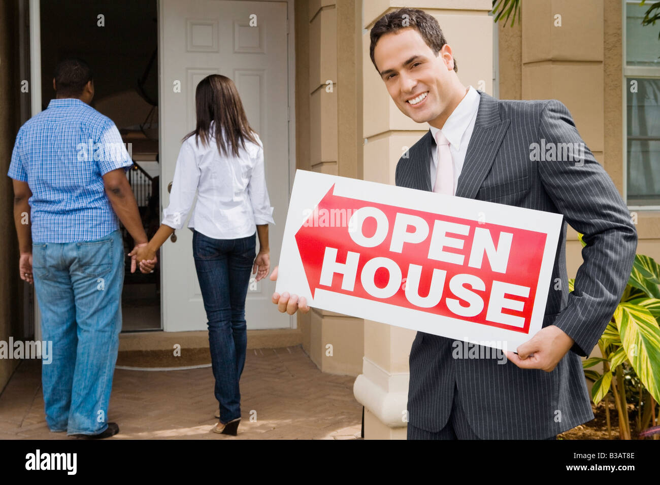 Hispanic real estate agent holding Open House sign Stock Photo - Alamy