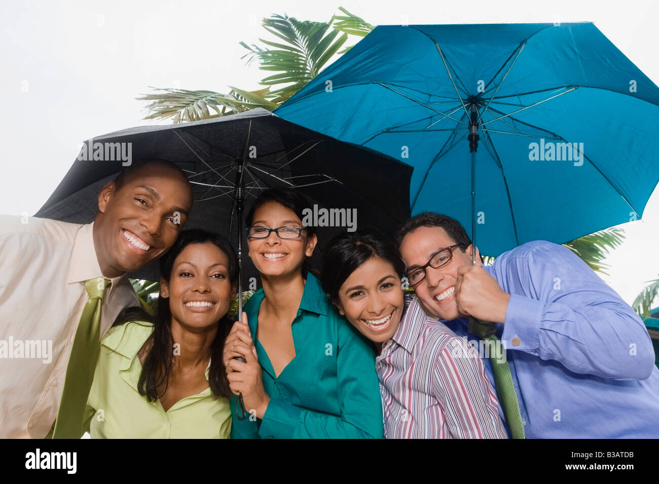 Hispanic businesspeople standing under umbrellas Stock Photo - Alamy