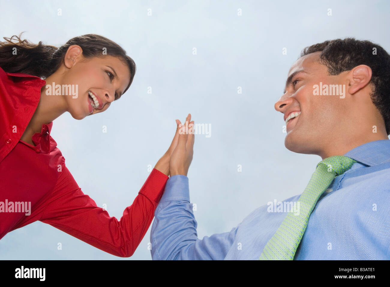 Hispanic business people high-fiving Stock Photo - Alamy