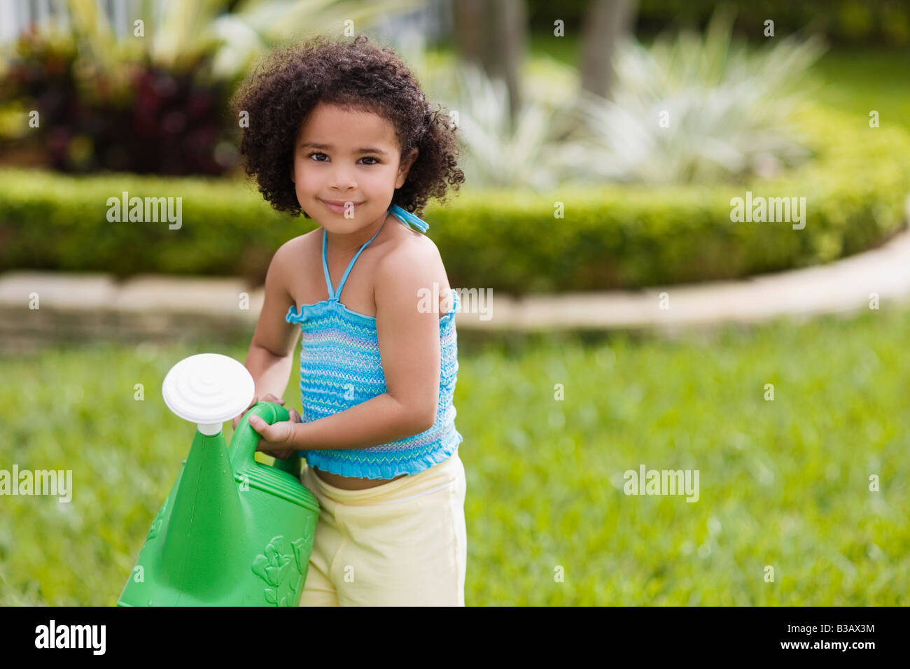 African girl holding watering can Stock Photo - Alamy
