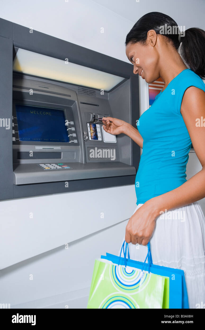 Hispanic woman using atm Stock Photo - Alamy