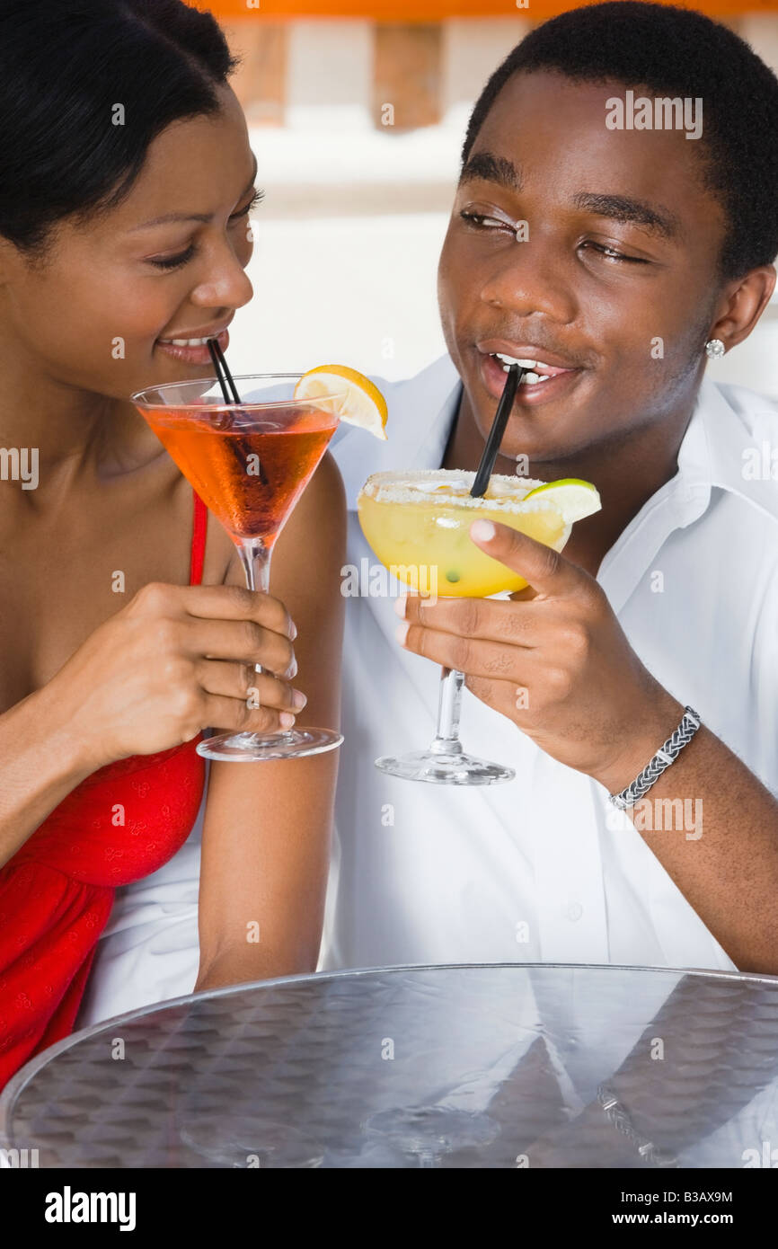 Multi-ethnic couple drinking cocktails Stock Photo - Alamy