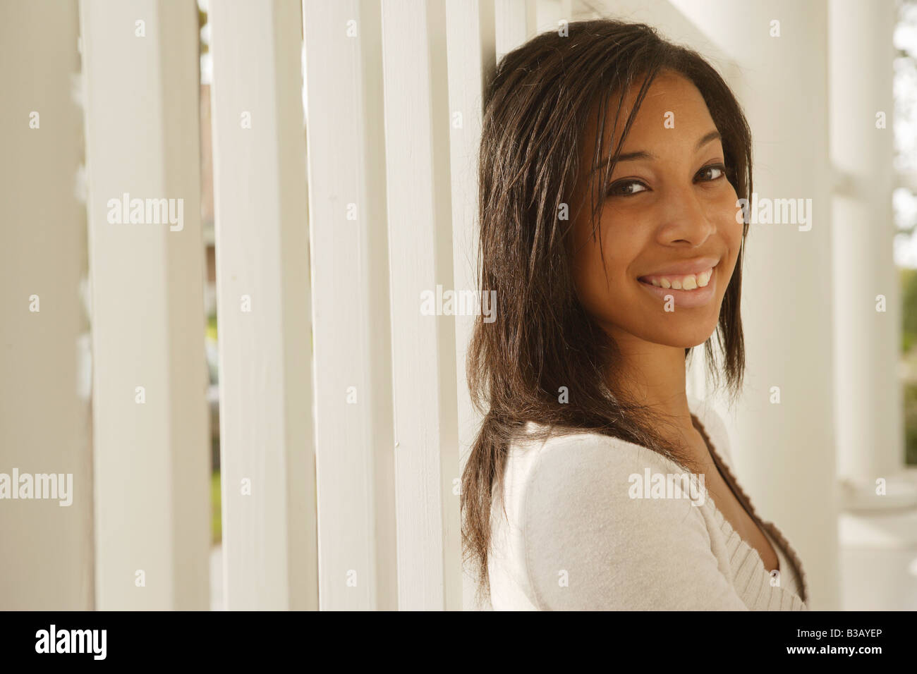 African woman leaning on porch railing Stock Photo - Alamy