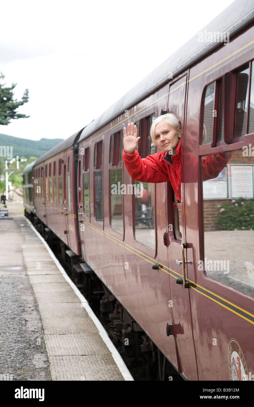 Sad farewell as person leaves on a train. Girl wearing Red Coat and ...