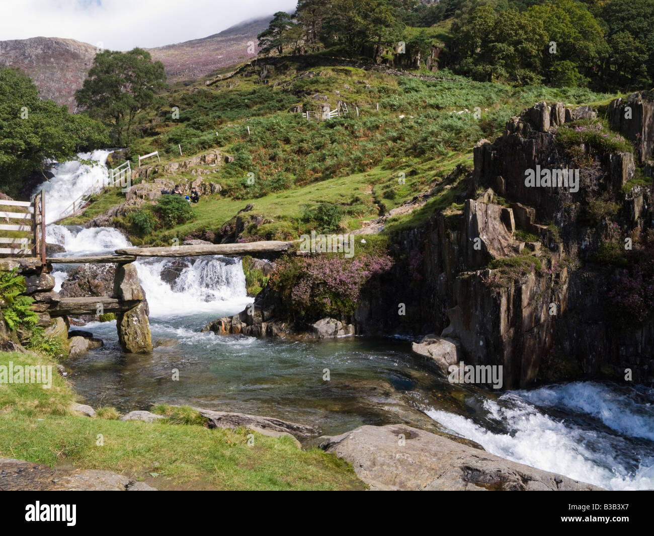 Old stone slab footbridge over Afon Cwm Llan waterfall and pools in ...