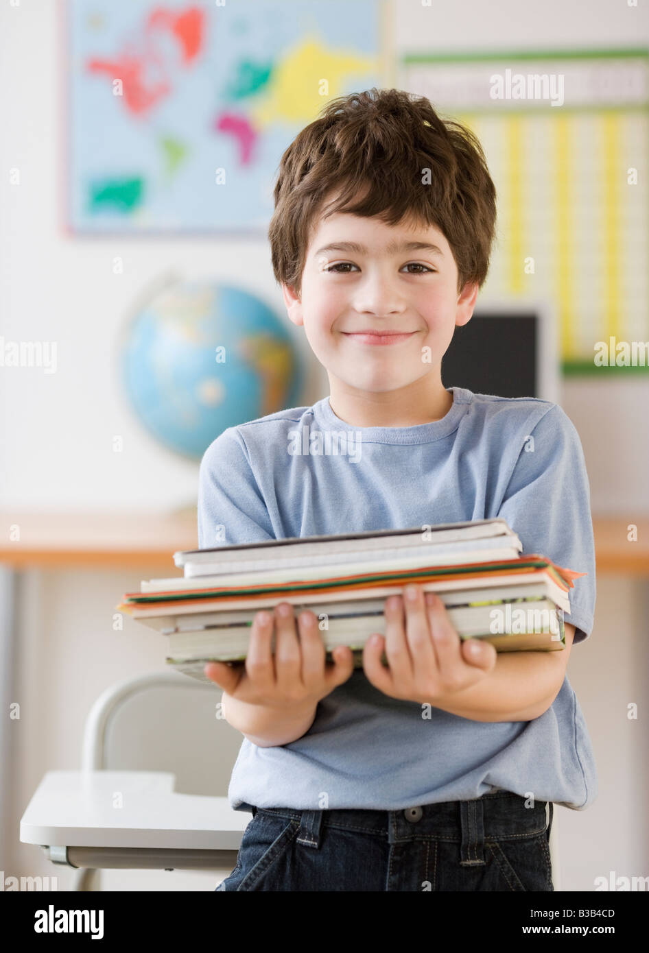 Hispanic boy holding stack of school books Stock Photo - Alamy