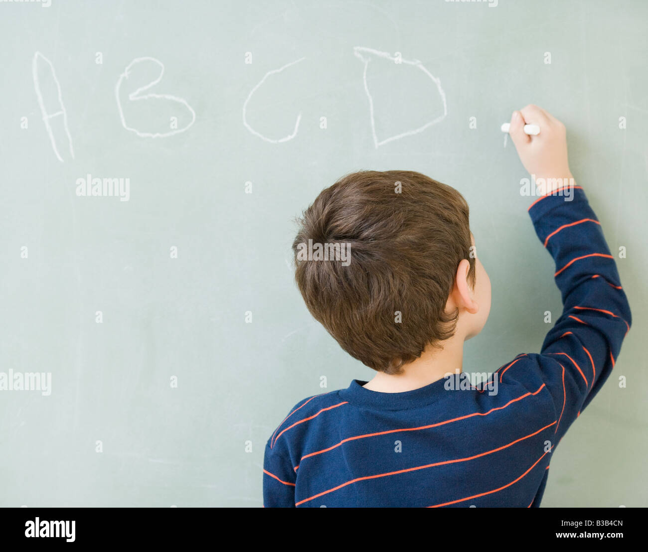 Hispanic boy writing on blackboard Stock Photo - Alamy