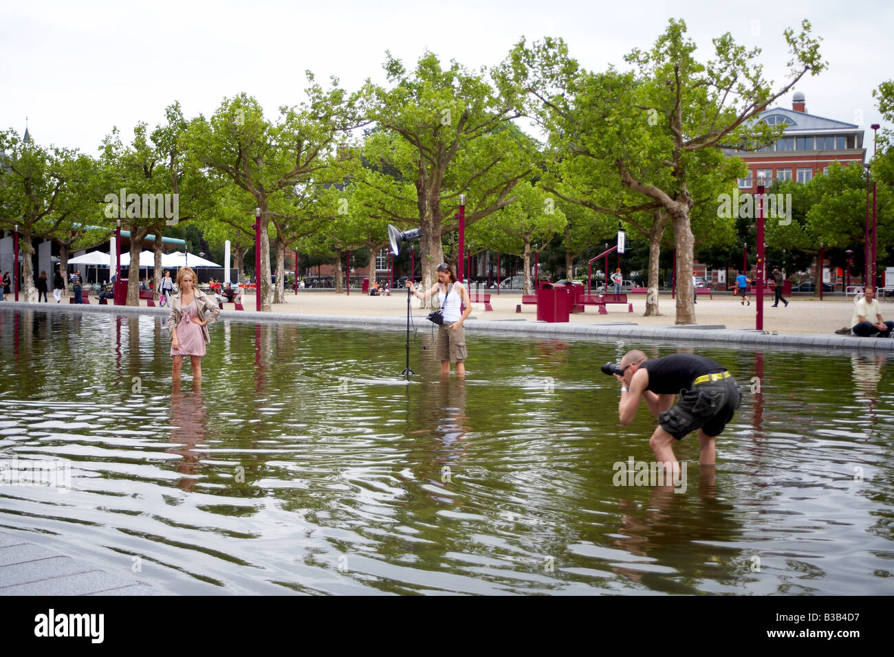Photographer, assistant and model in a water feature in Amsterdam Stock ...
