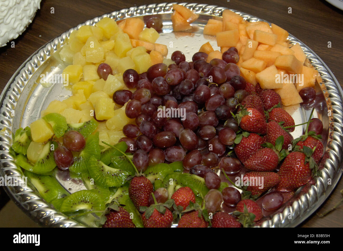 silver fruit platter including pineapple, strawberries, grapes, kiwi ...