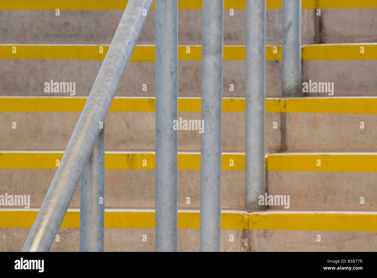 Metal railings and concrete steps with yellow painted edges at a ...