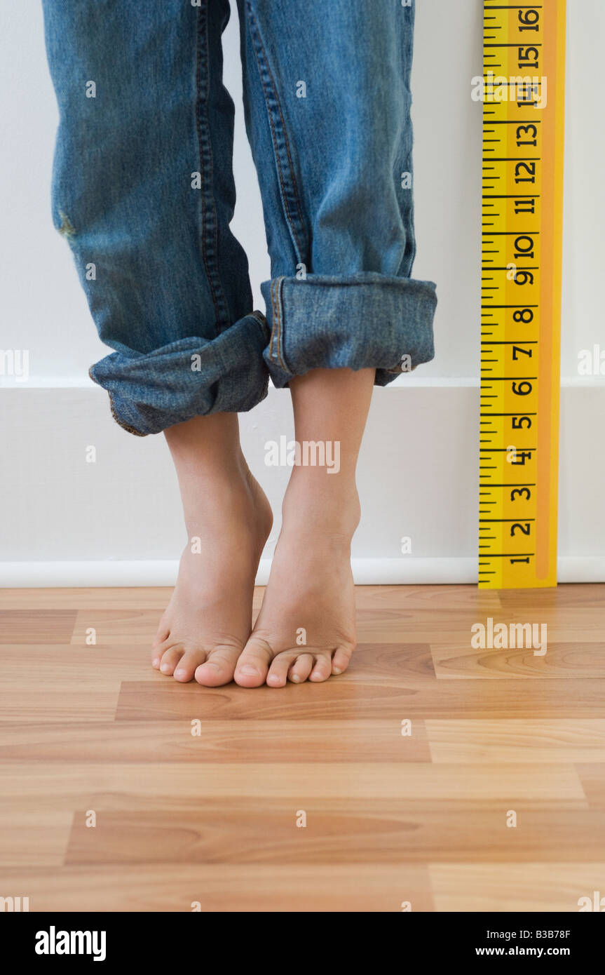 Boy standing on tiptoes next to ruler Stock Photo - Alamy