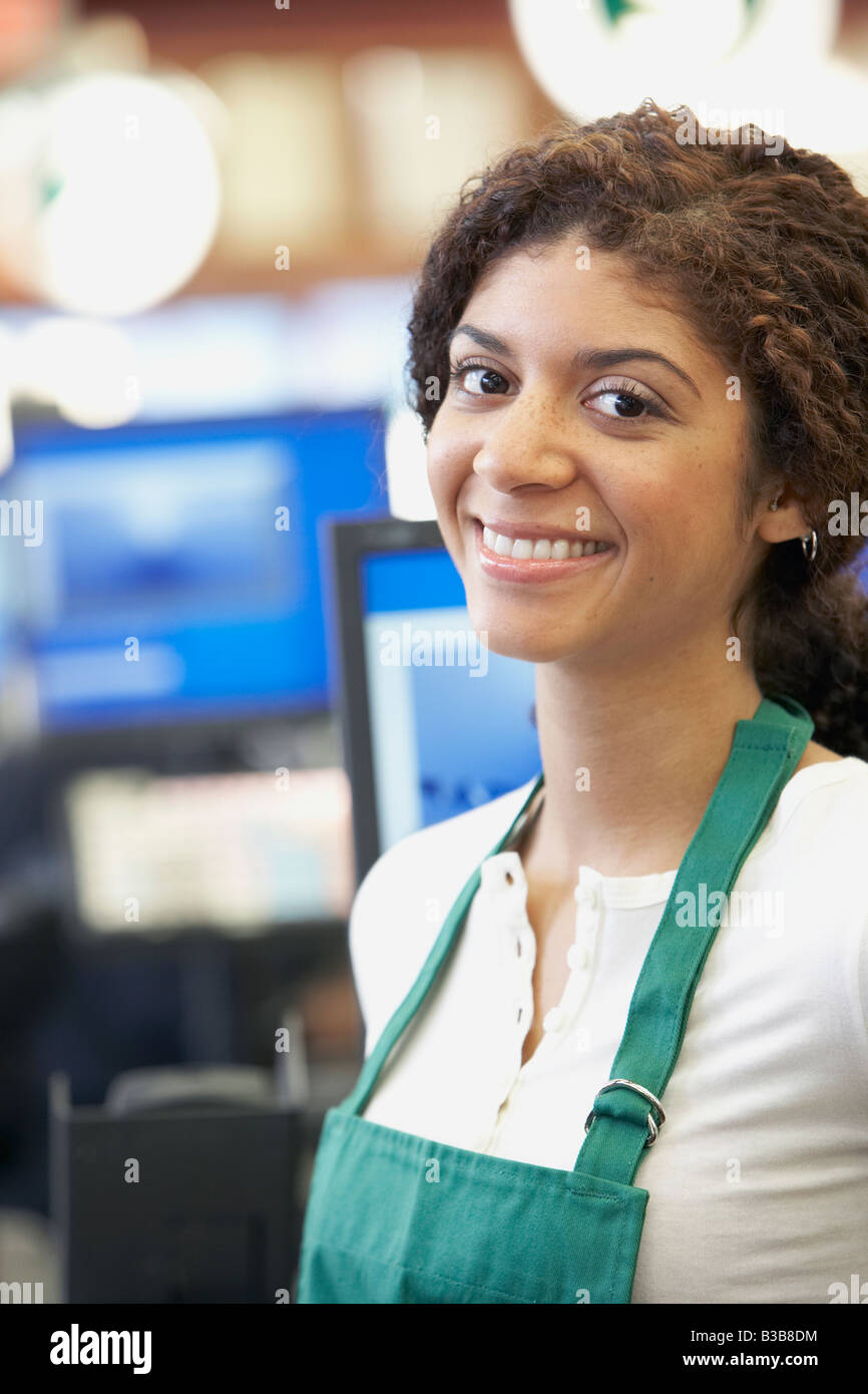 Mixed Race cashier wearing apron Stock Photo - Alamy