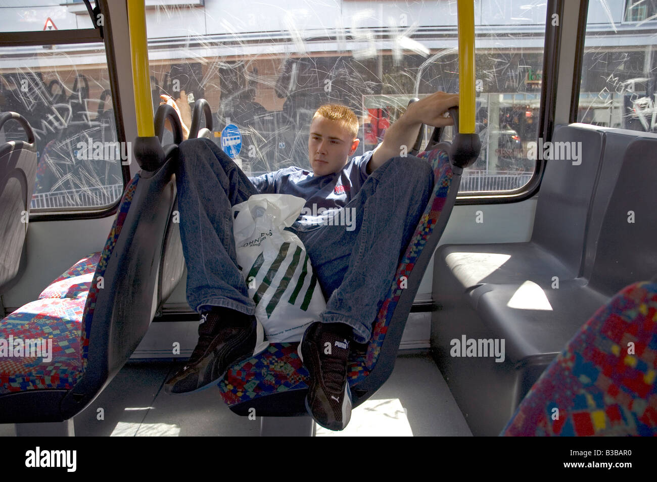 A young man looking thoughtful depressed whilst traveling on a bus ...