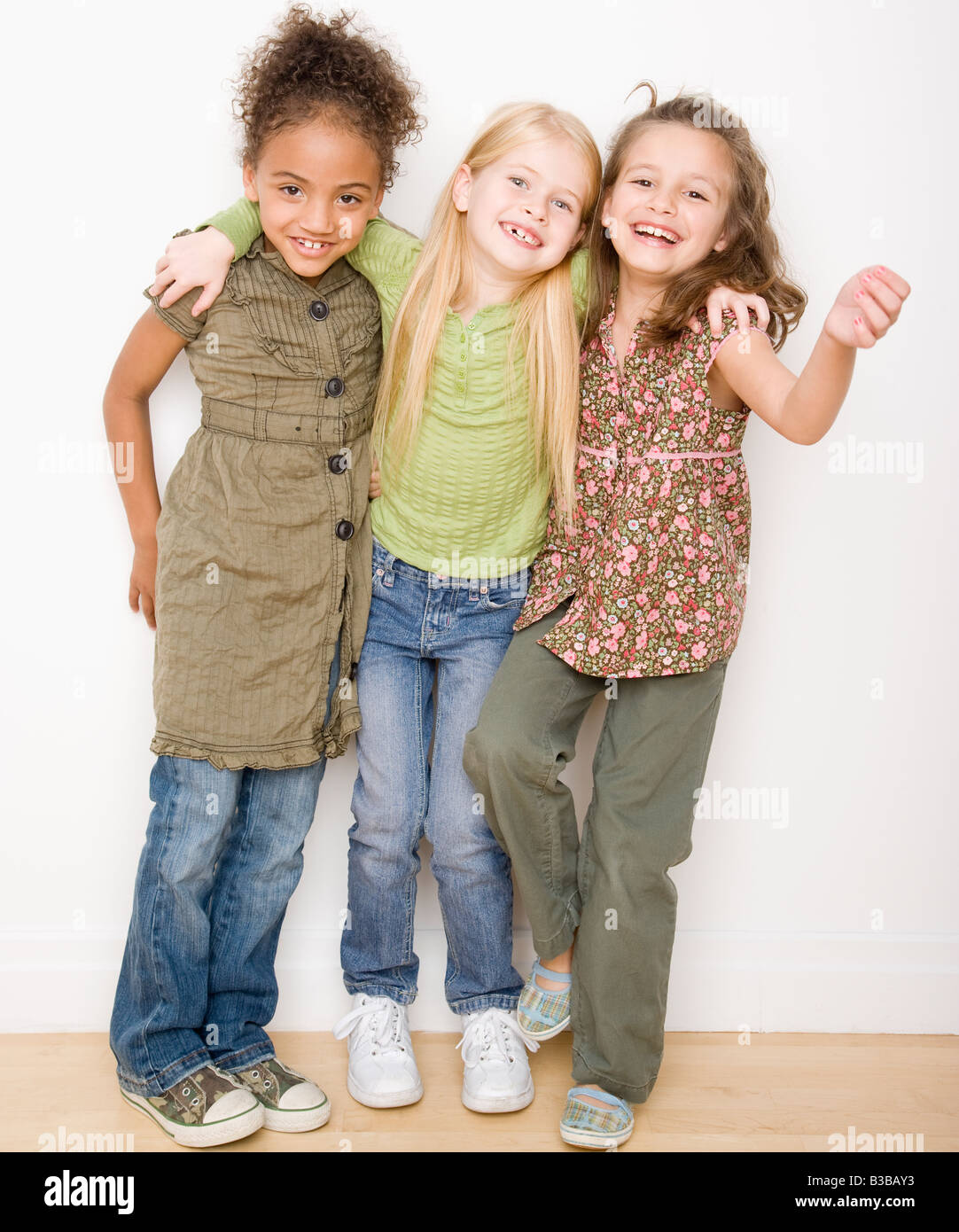 Multi-ethnic girls hugging Stock Photo - Alamy