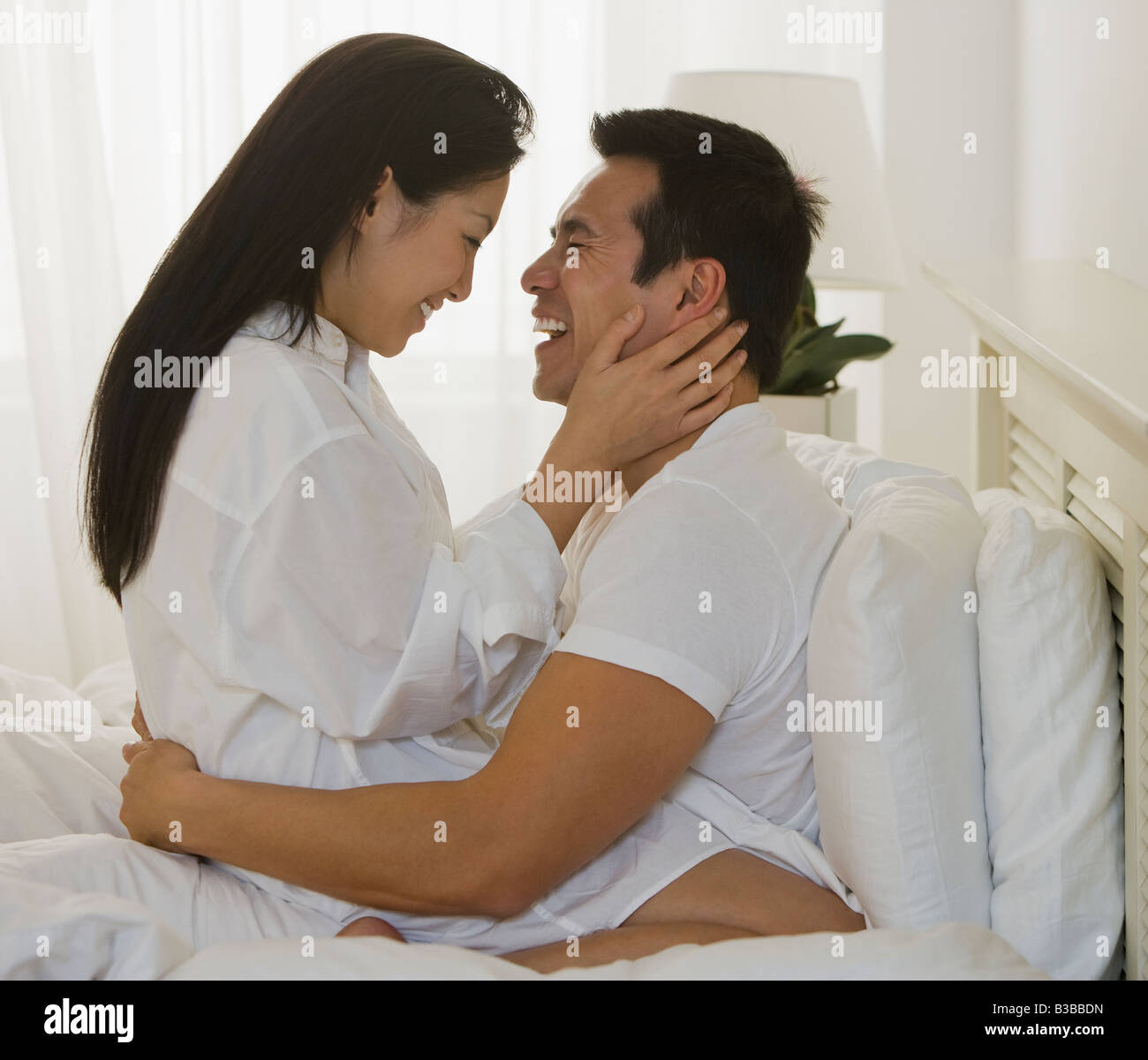 Asian couple hugging in bed Stock Photo - Alamy