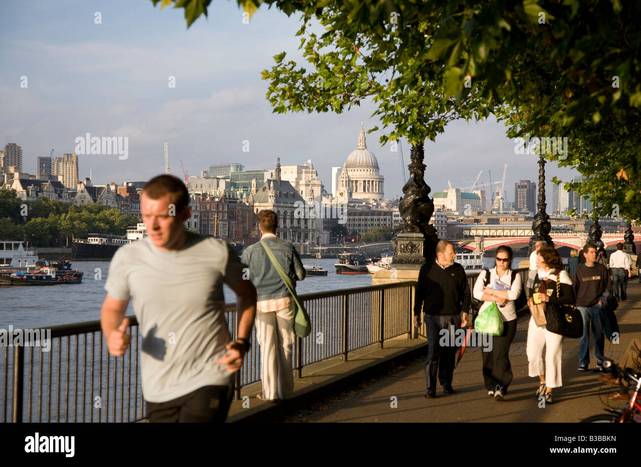 man jogging on London's South Bank with city of London in backround ...