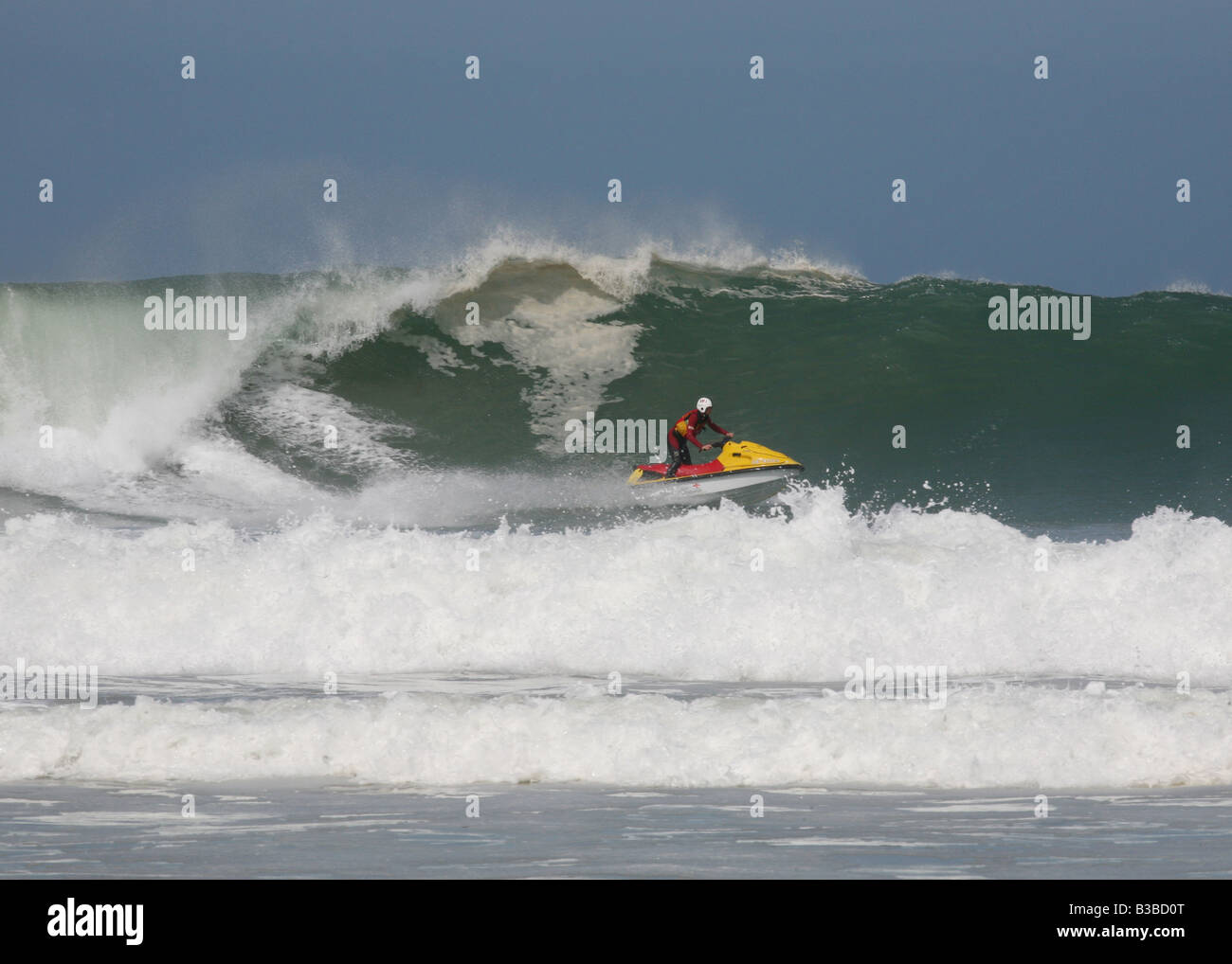 RNLI Lifeguard on a jet ski in big surf off St Agnes, Cornwall, UK ...