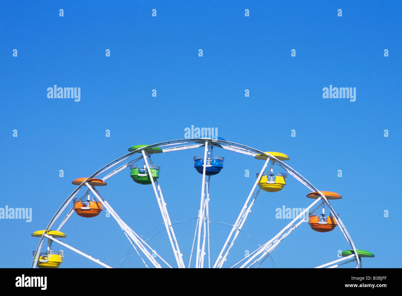 Ferris wheel with colorful circle of multi color buckets in red, green ...