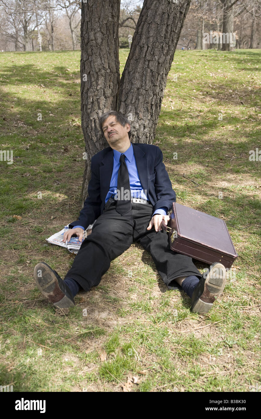 Exhausted from looking for work man in his early sixties resting under ...