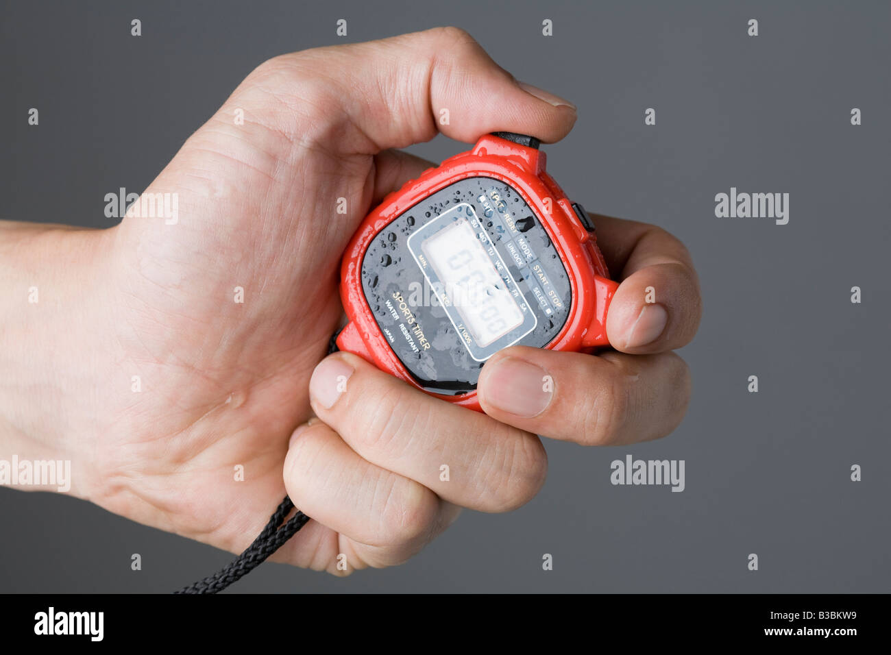 Hand of man holding stopwatch Stock Photo - Alamy