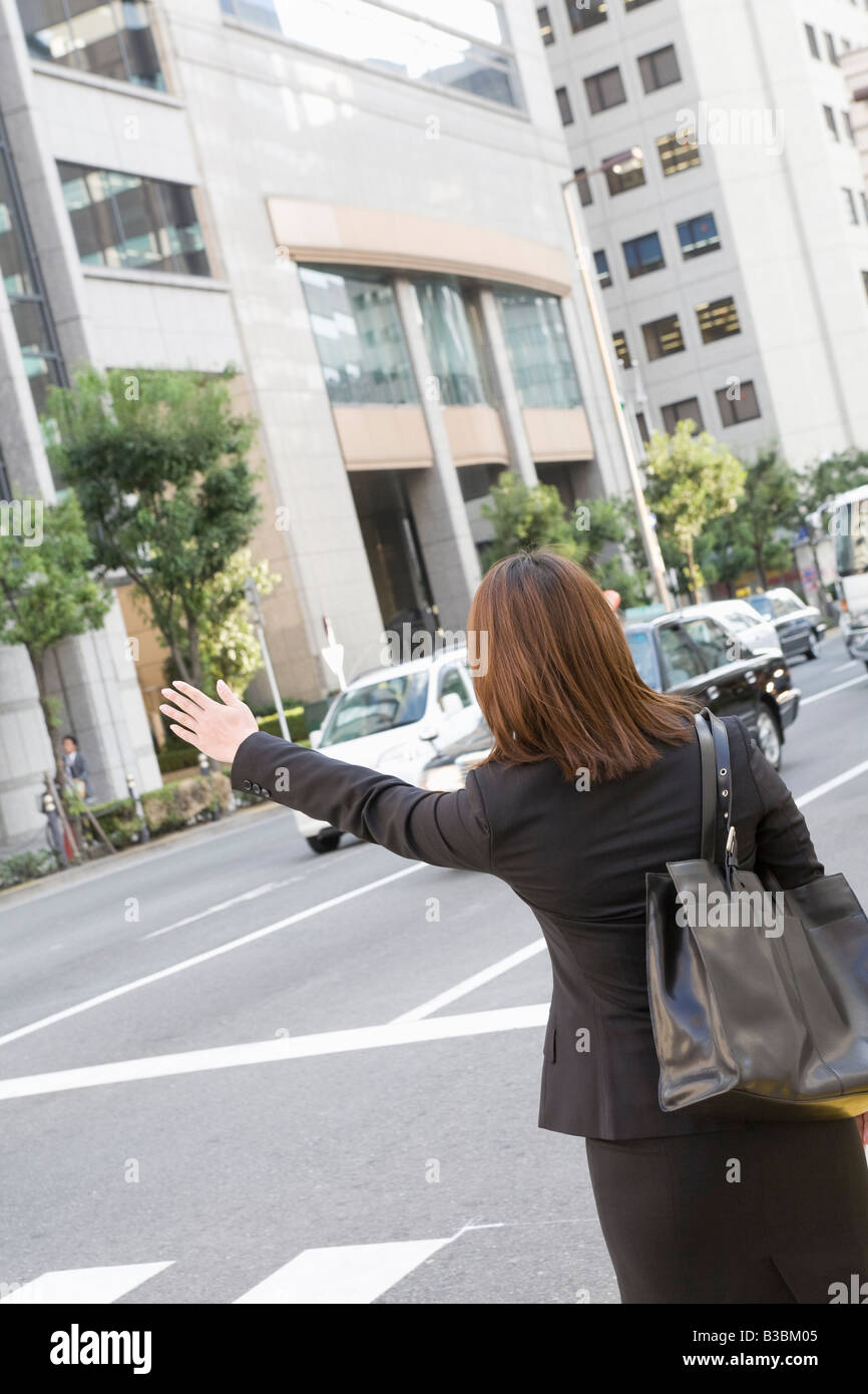 Businesswoman hailing taxi Stock Photo - Alamy