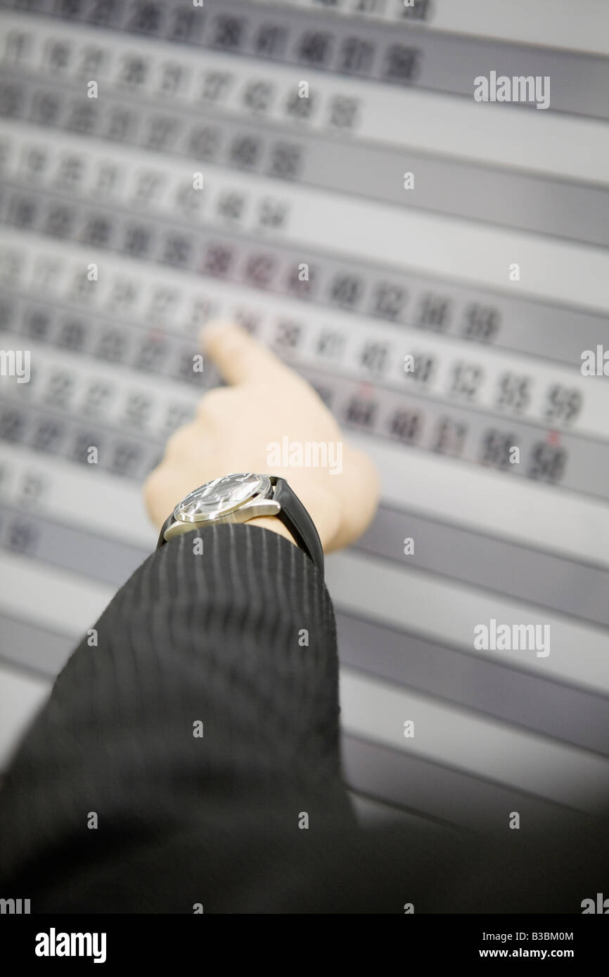 Businessman pointing at timetable Stock Photo - Alamy