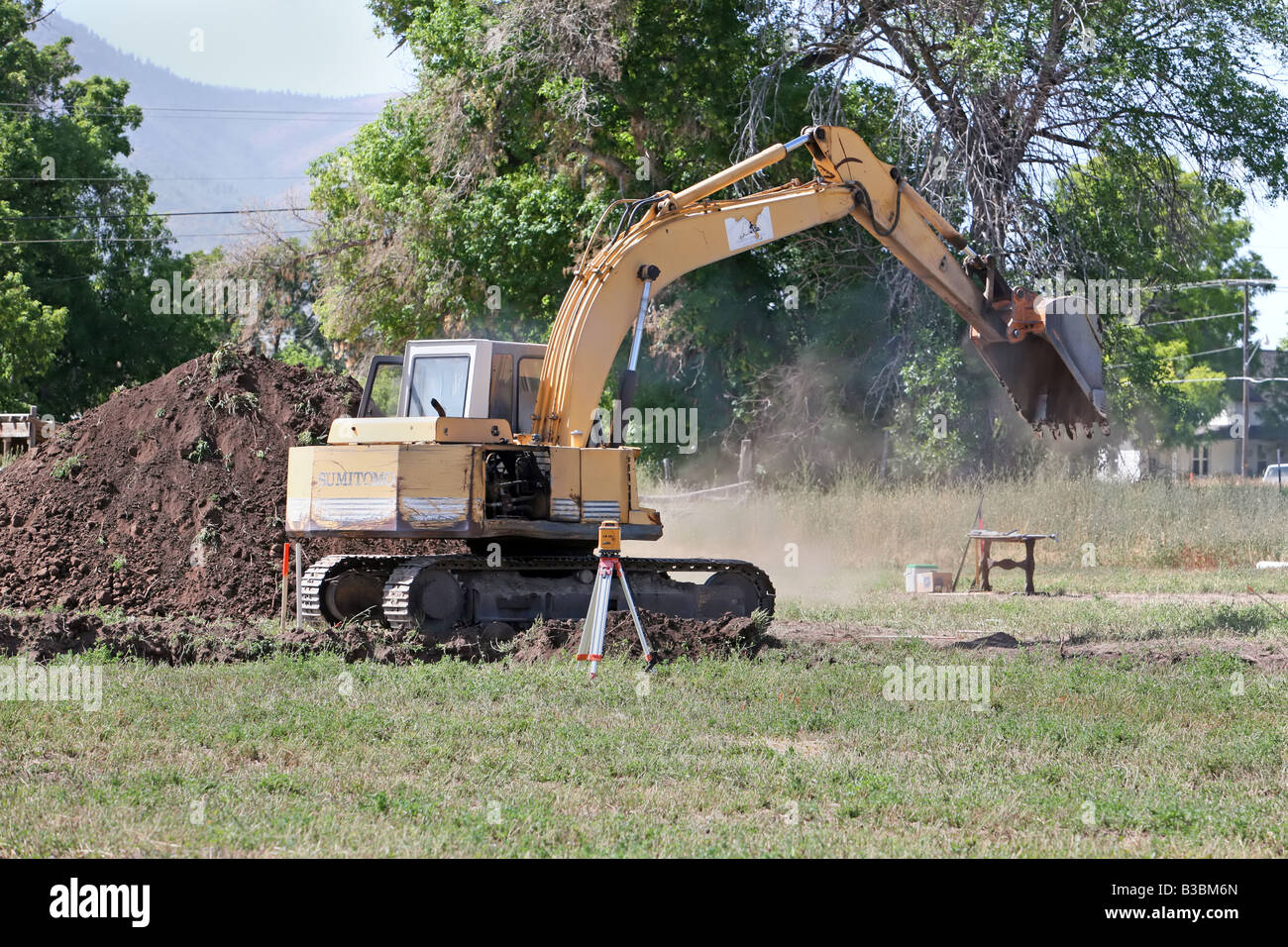 Photo of a large excavator tracked backhoe working and helping to build ...