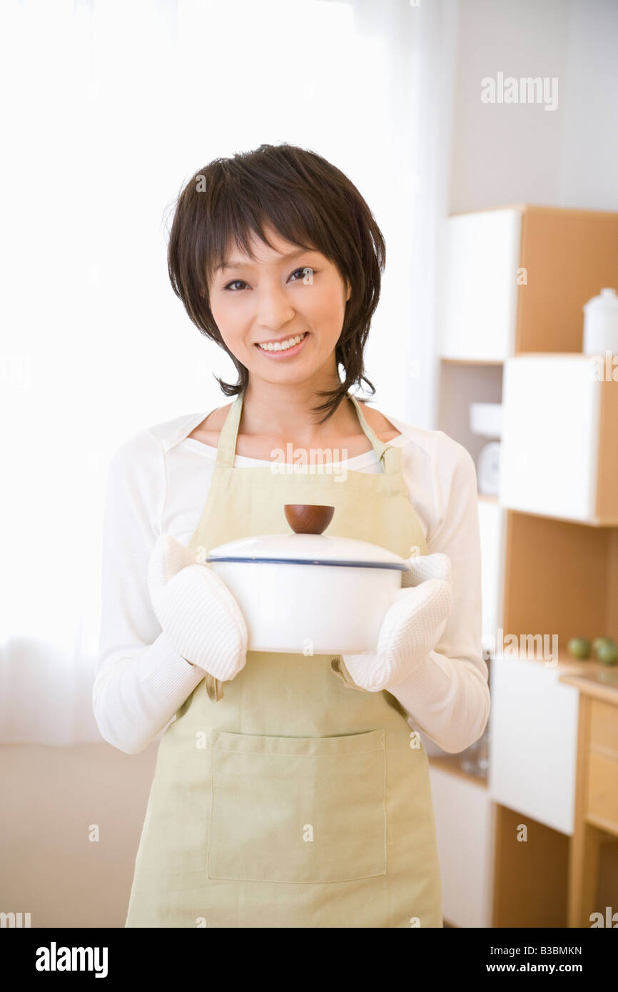 Young woman holding pan Stock Photo - Alamy